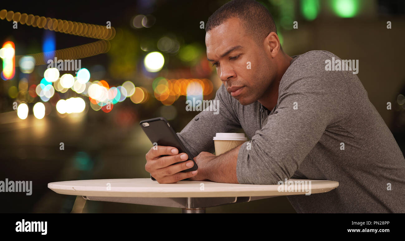 Man sitting alone at outdoor cafe drinking coffee at night Stock Photo ...
