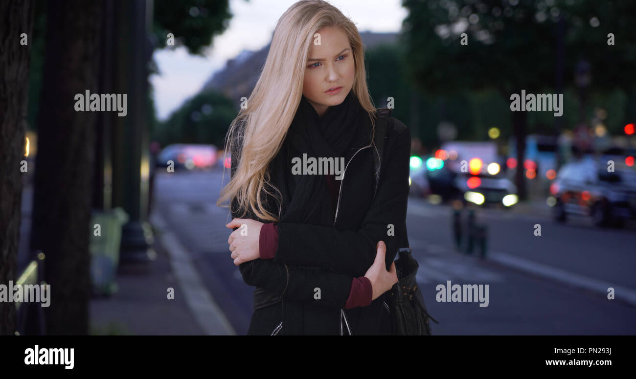Stunning modern white woman poses for camera while standing on sidewalk ...