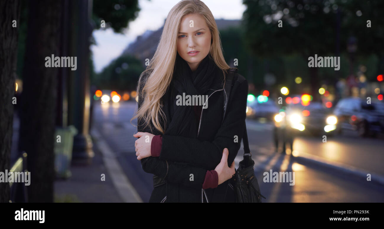 Stunning modern white woman poses for camera while standing on sidewalk ...