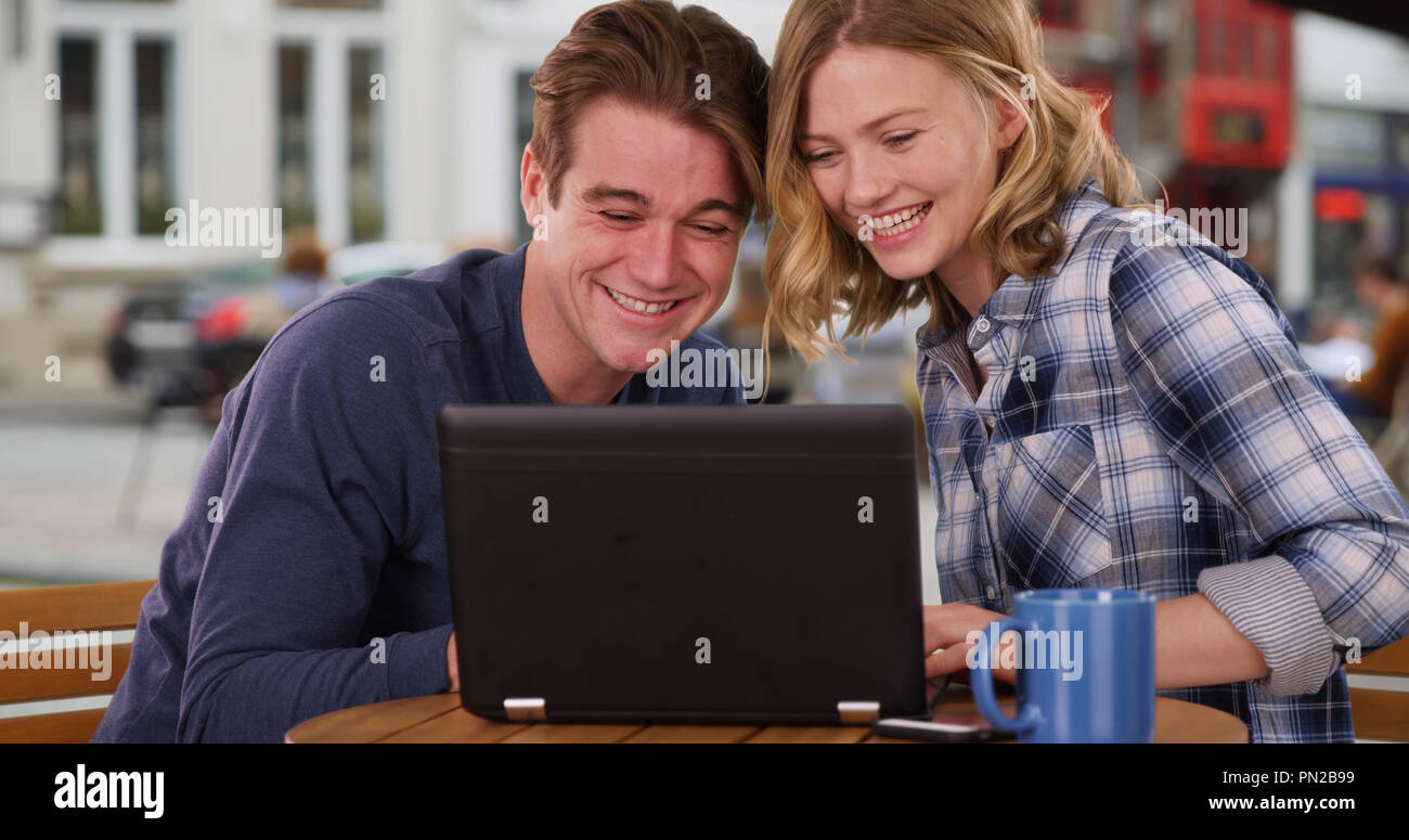 Happy Caucasian man and woman watching video on laptop laughing Stock ...
