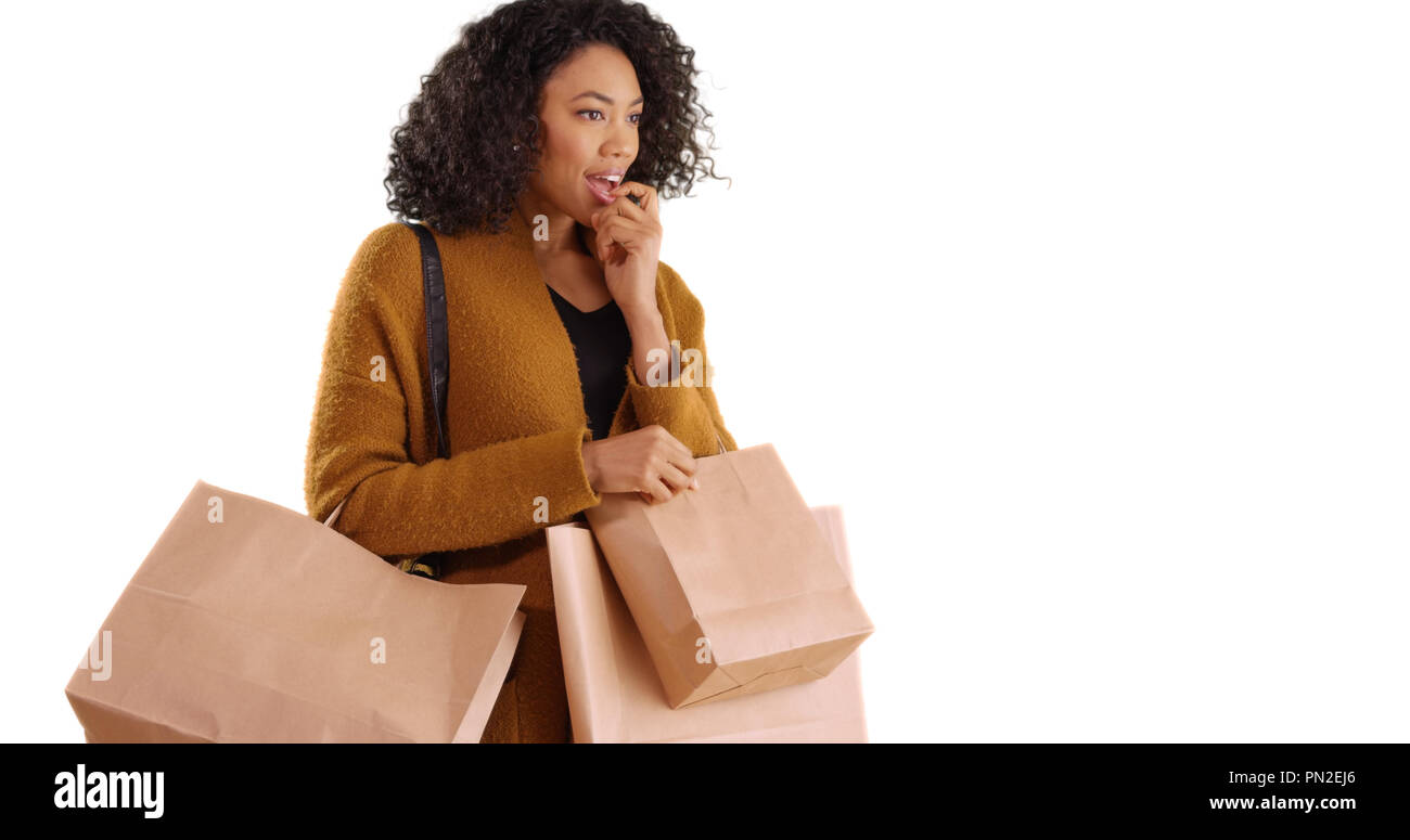 Black millennial female out shopping checking something out on white ...