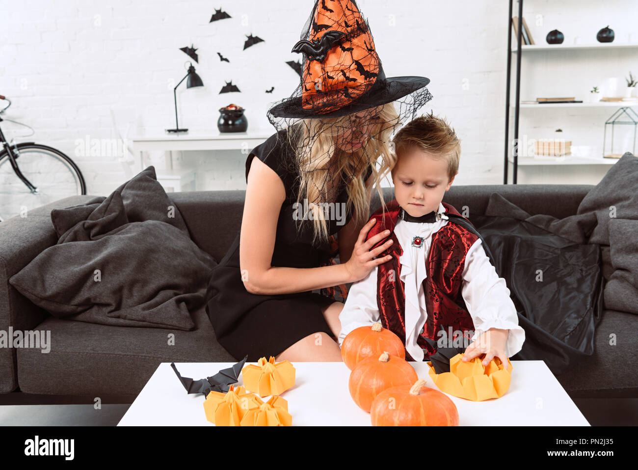 portrait of mother and son in halloween costumes sitting at coffee ...