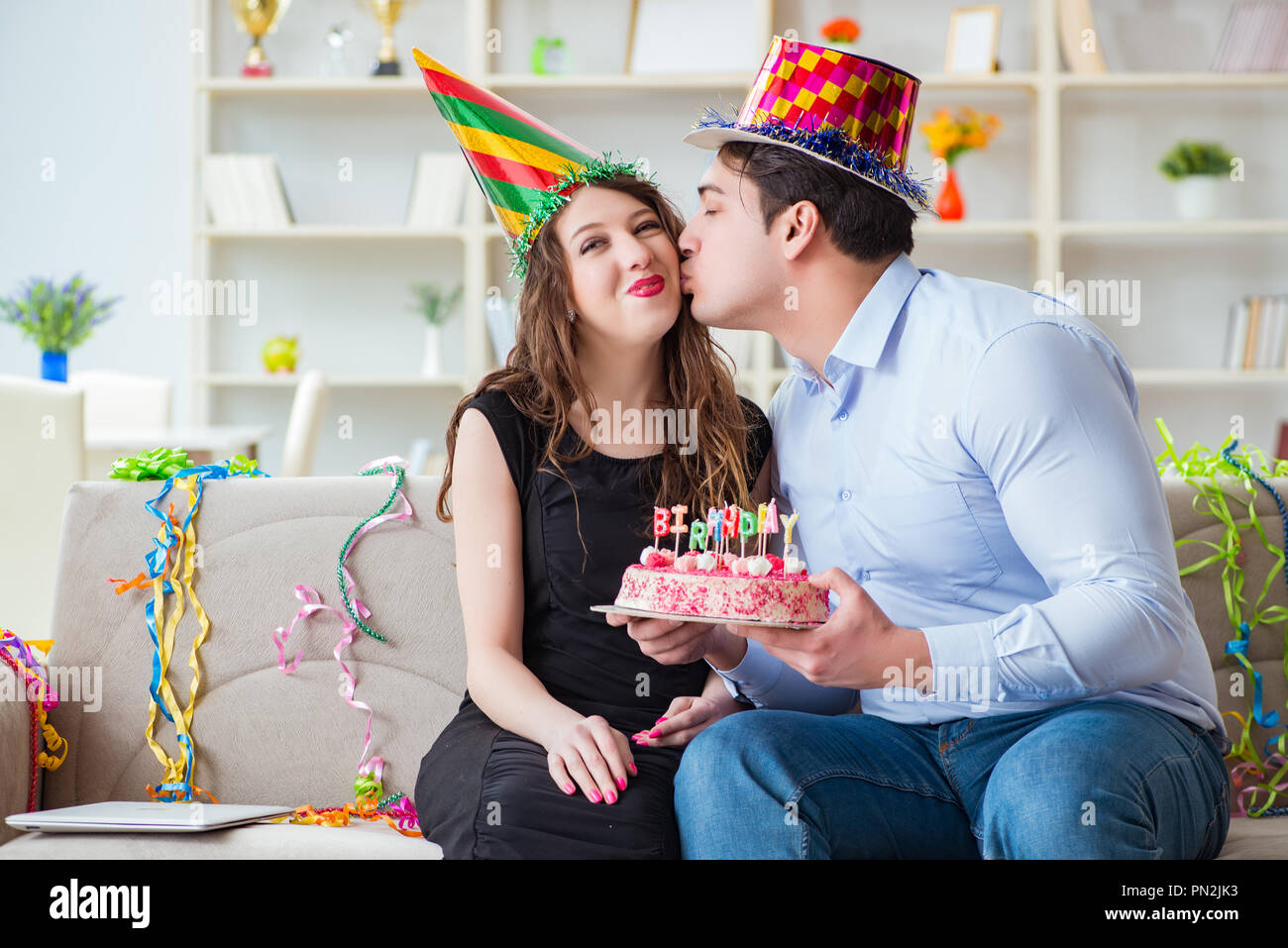 Young couple celebrating birthday with cake Stock Photo - Alamy