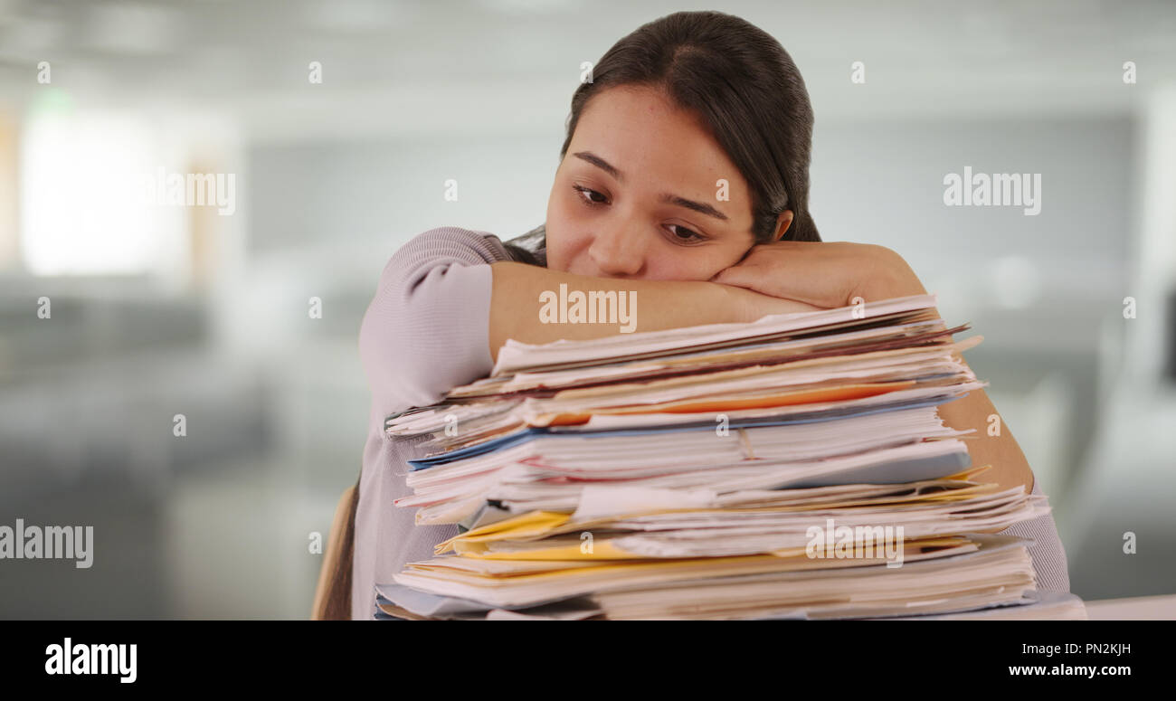 Latino office worker stressed from too much paper work Stock Photo - Alamy