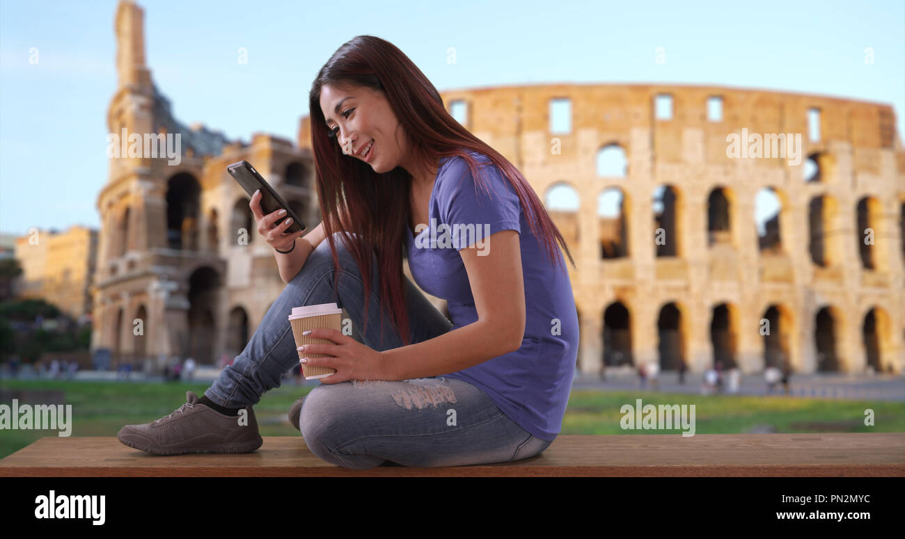 Happy Japanese female drinking coffee and texting her boyfriend near ...