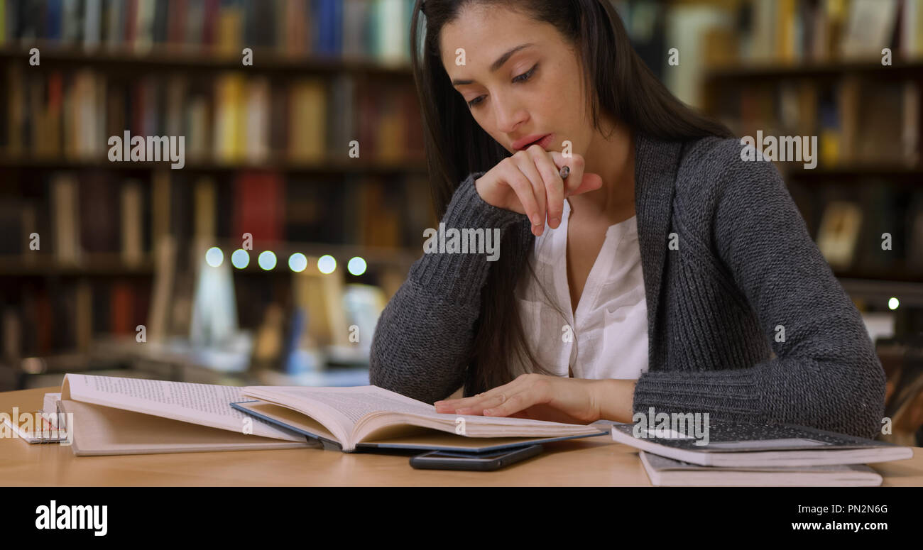 Attractive Latina female studies for final exams at the library Stock ...