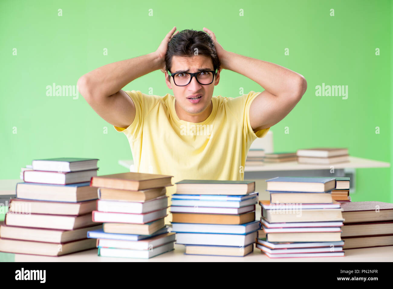 Student with too many books to read before exam Stock Photo - Alamy