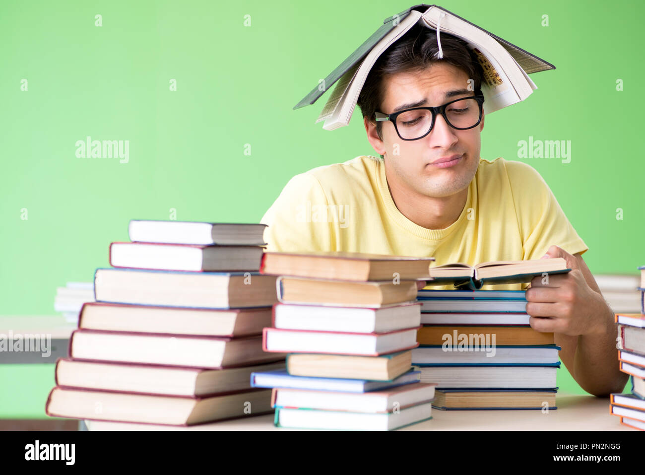 Student with too many books to read before exam Stock Photo - Alamy