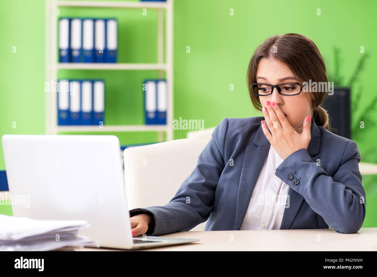 Young female employee very busy with ongoing paperwork Stock Photo - Alamy