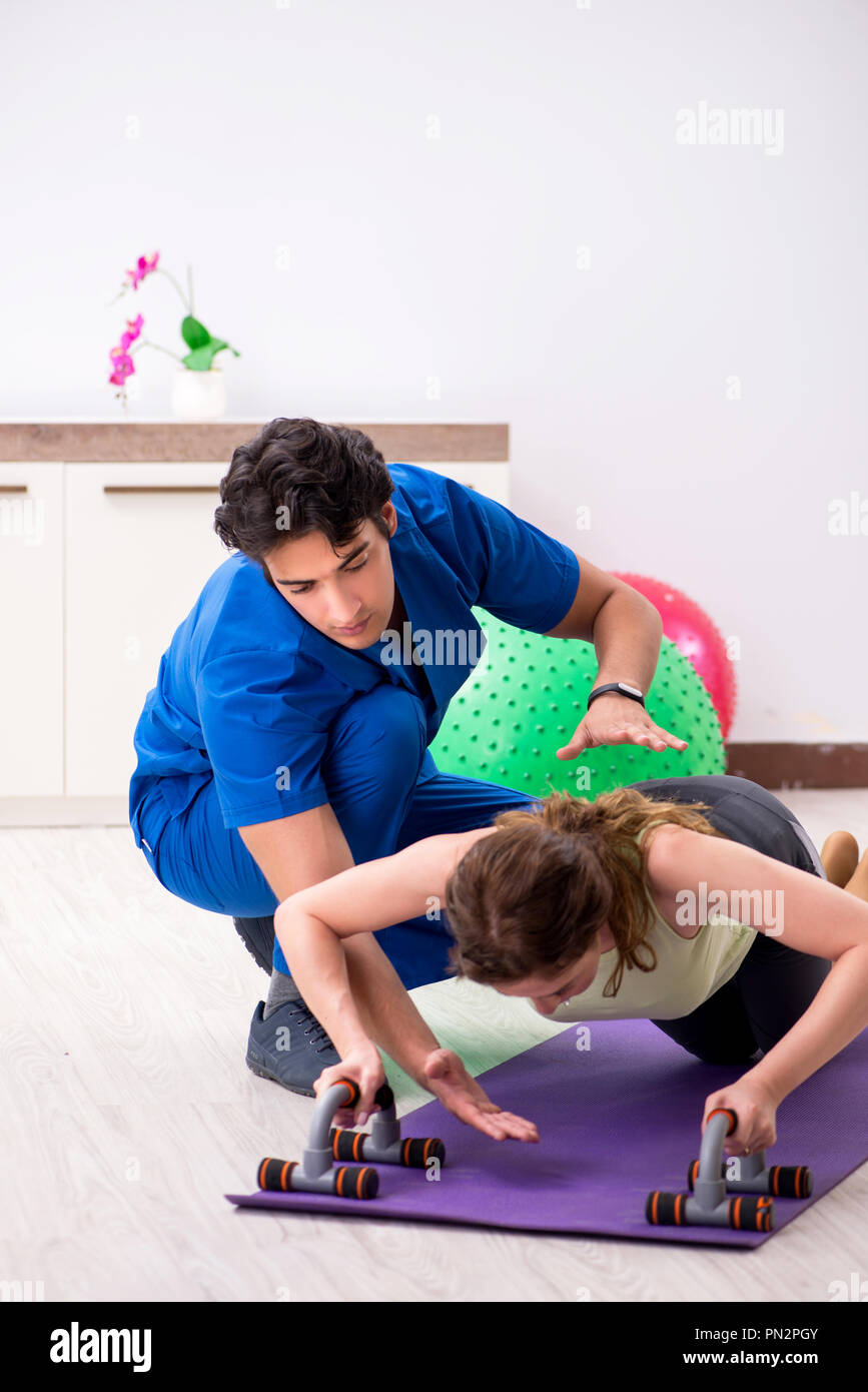 Fitness instructor helping sportsman during exercise Stock Photo - Alamy