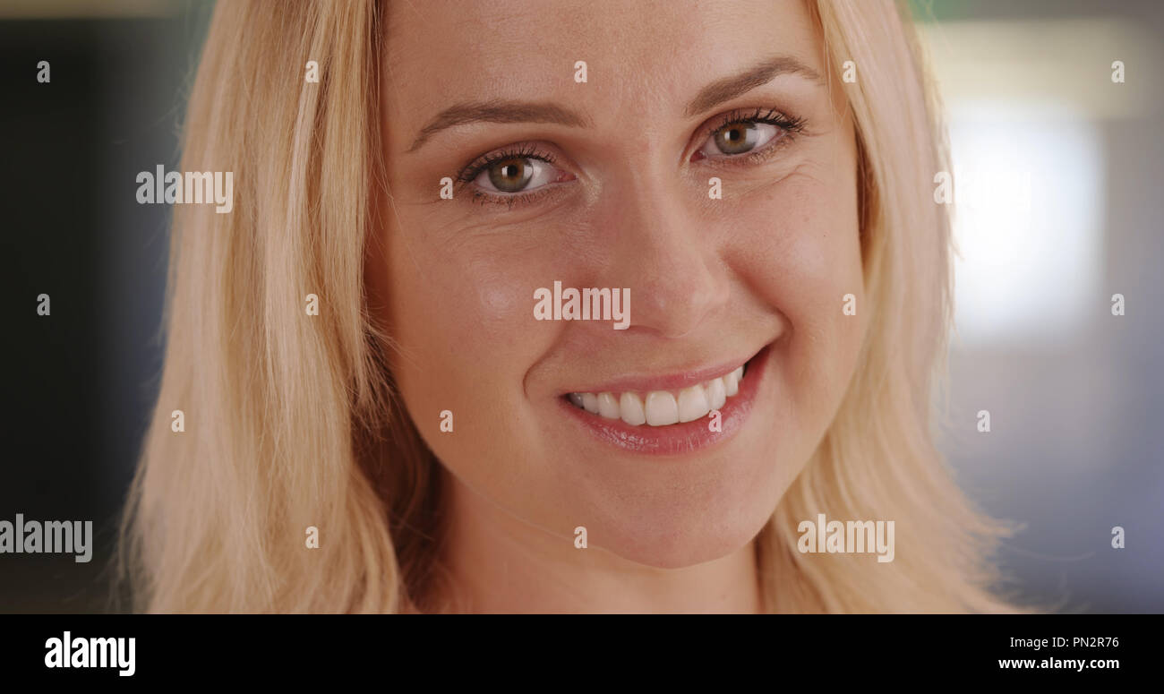 Pretty white young lady smiling casually at camera alone in indoor ...