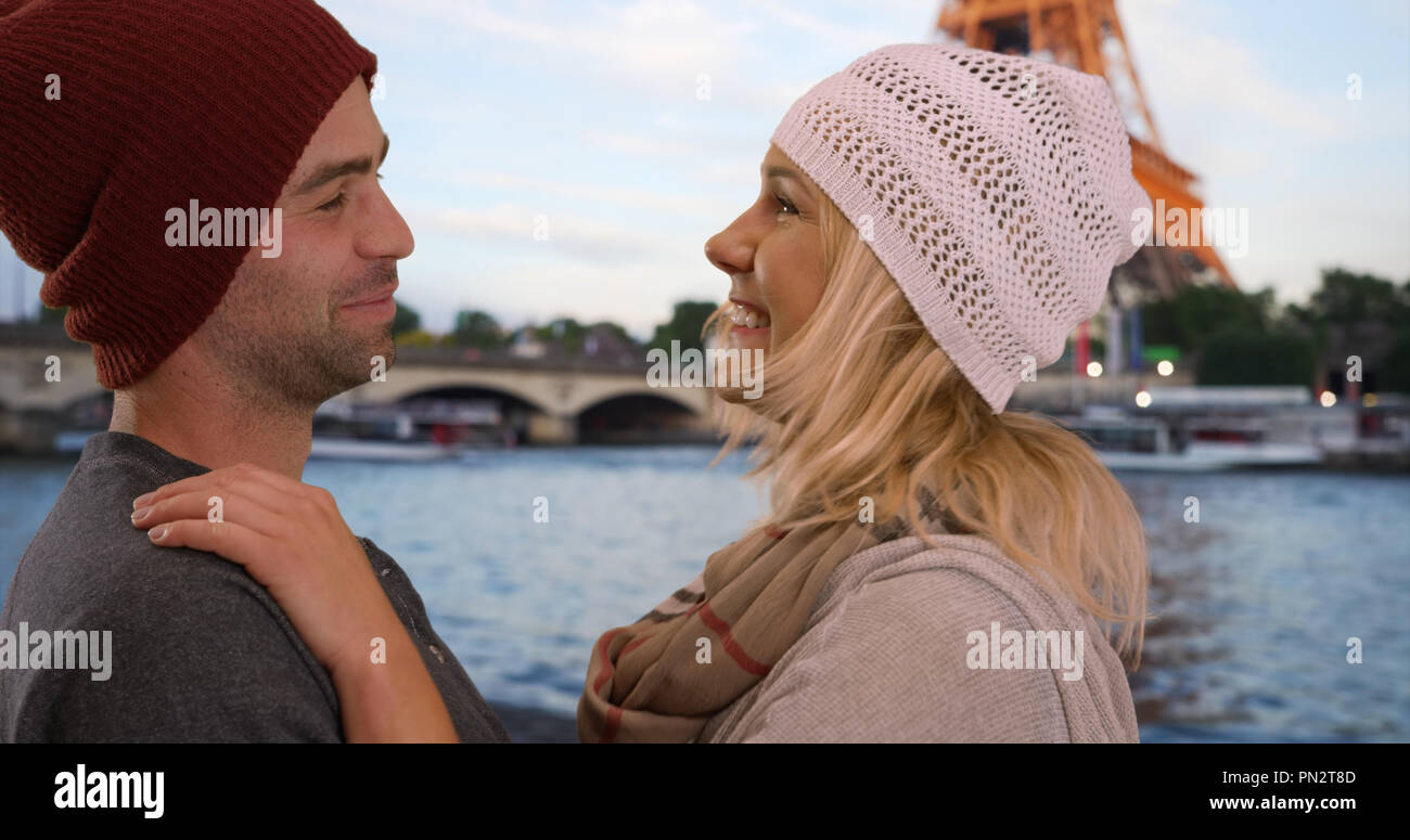 Romantic young couple gaze into each others eyes by the Seine Stock ...