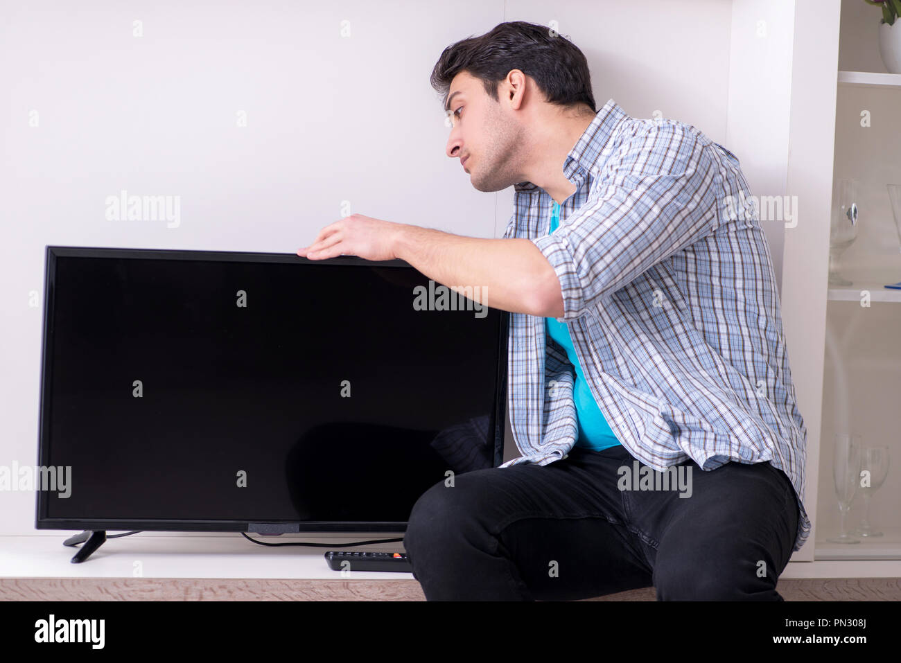 Man trying to fix broken tv Stock Photo - Alamy