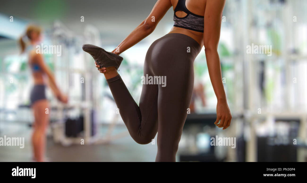 Shot of African female stretching her leg before her workout at the gym ...