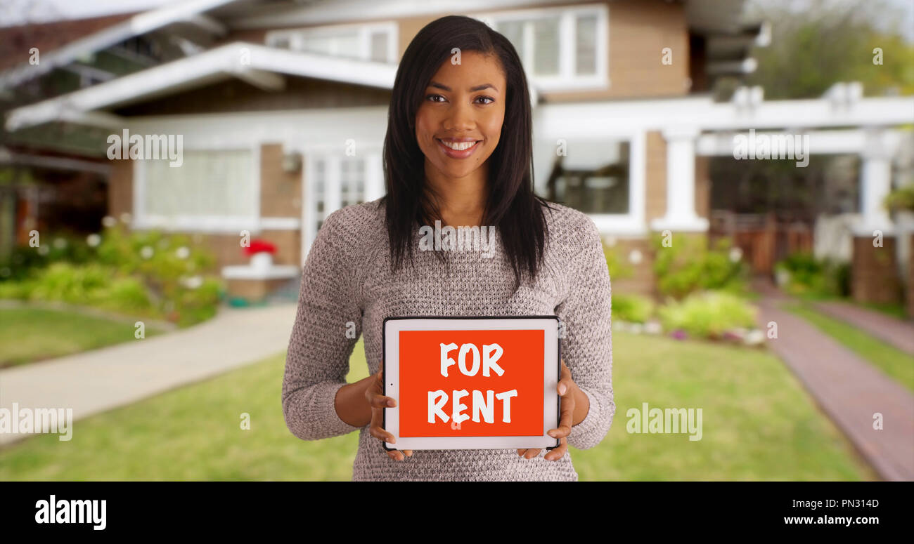 Portrait of cheerful black female advertising home for rent Stock Photo ...