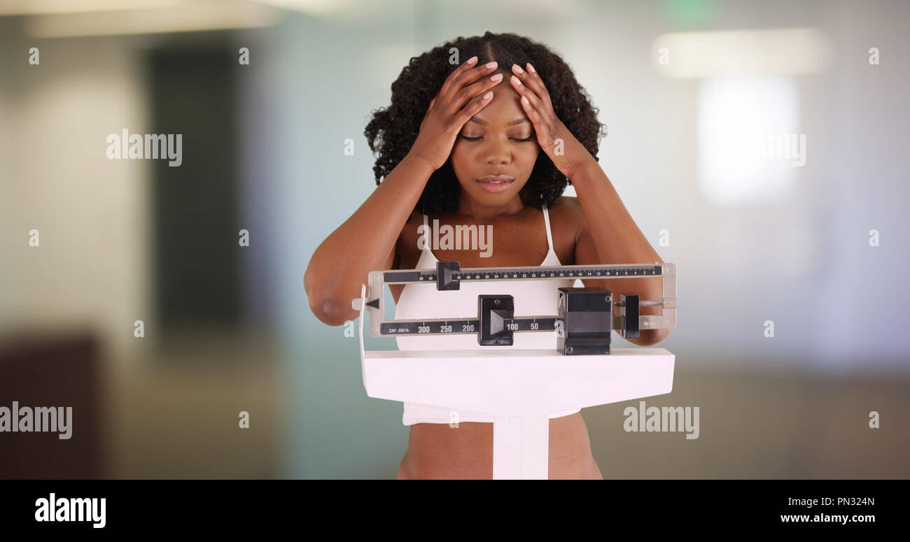 Unhappy young woman weighs herself scale frustrated with weight gain ...