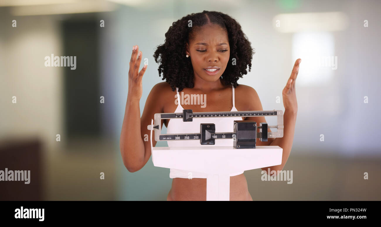 Unhappy young woman weighs herself scale frustrated with weight gain ...