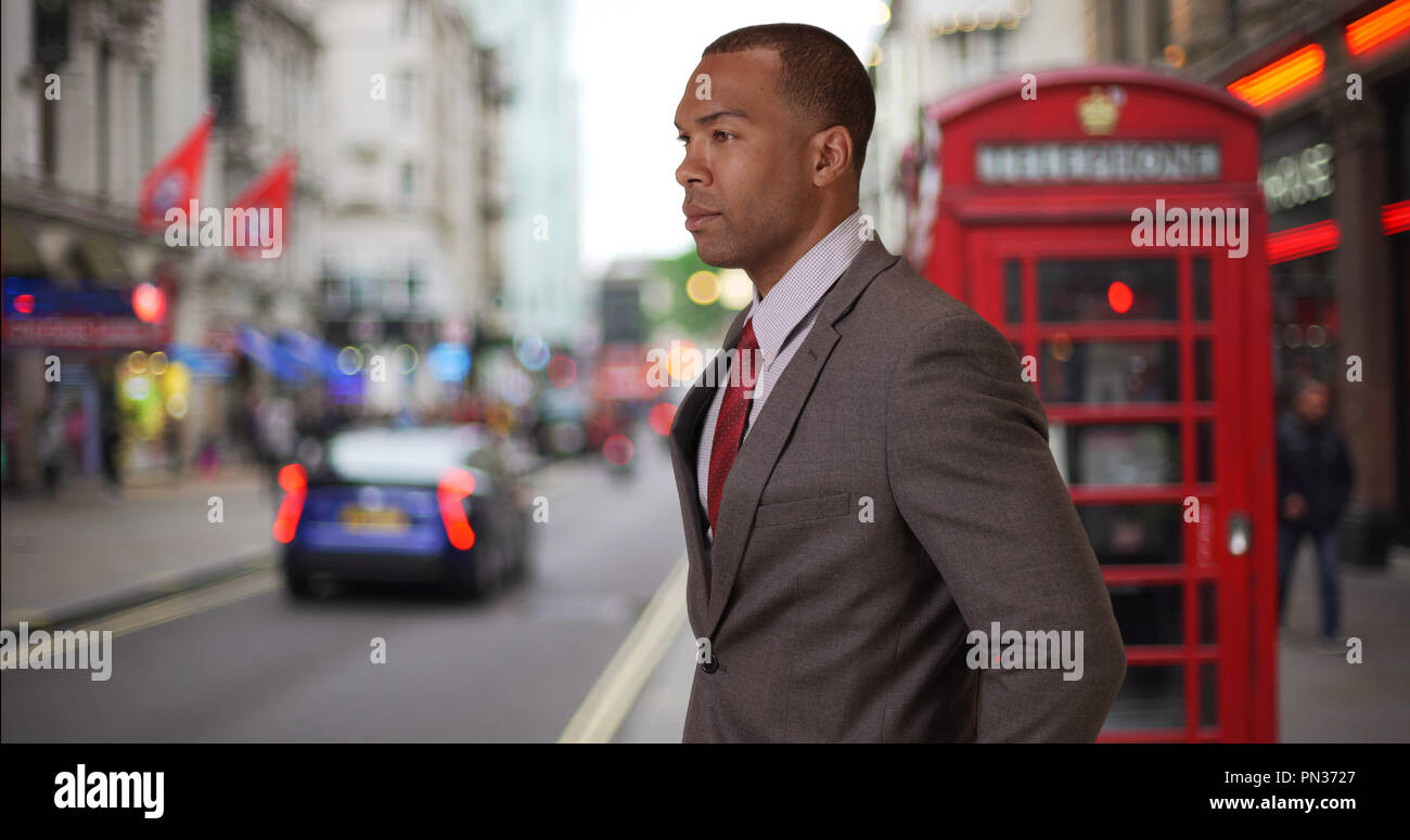 Young black businessman traveling in London takes look around the city ...