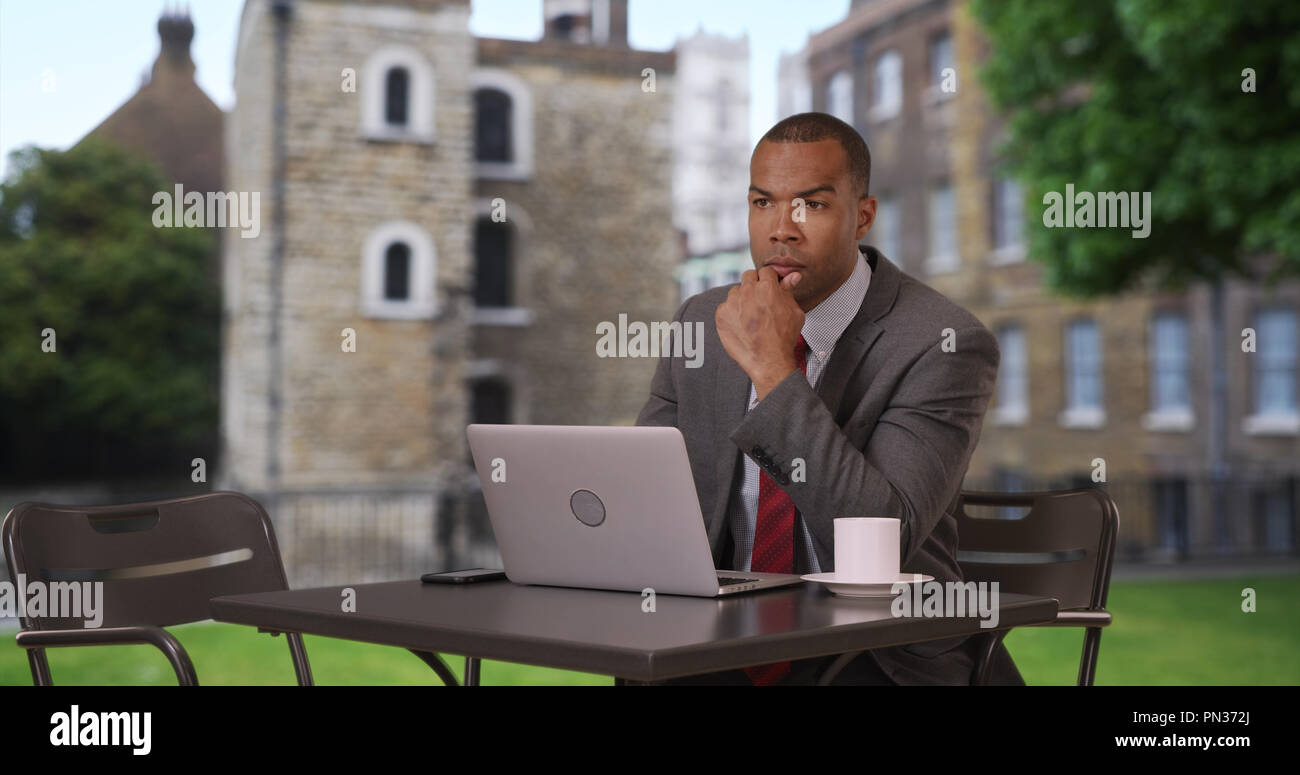 Hard-working black professional drinking coffee and using laptop in ...