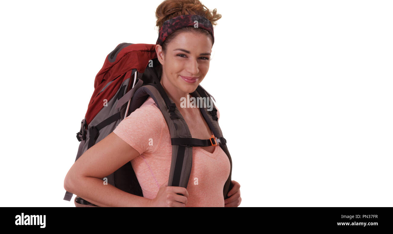 Portrait of smiling white woman wearing backpack posing on white ...