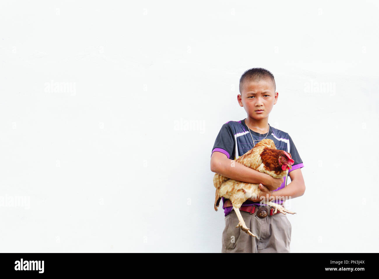 The boy in the upper body was carrying a brown chicken, sweating on his ...