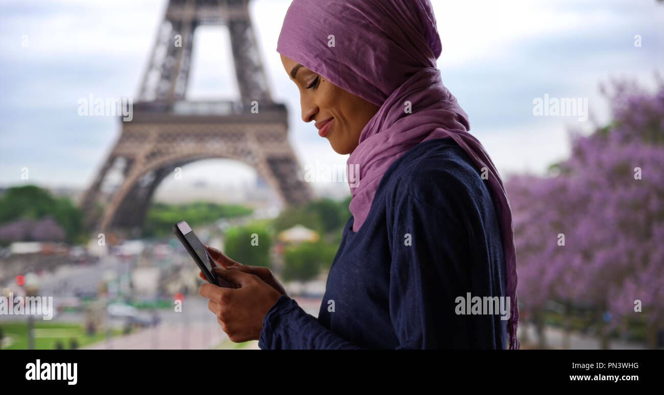 Young beautiful Muslim woman in Paris France texting near the Eiffel ...