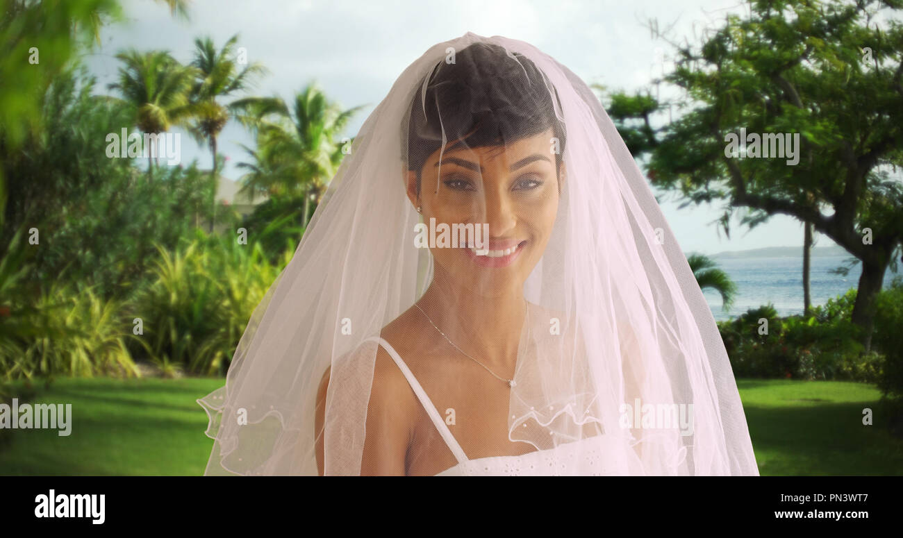 Blushing bride in St John island poses for portrait happy and smiling ...