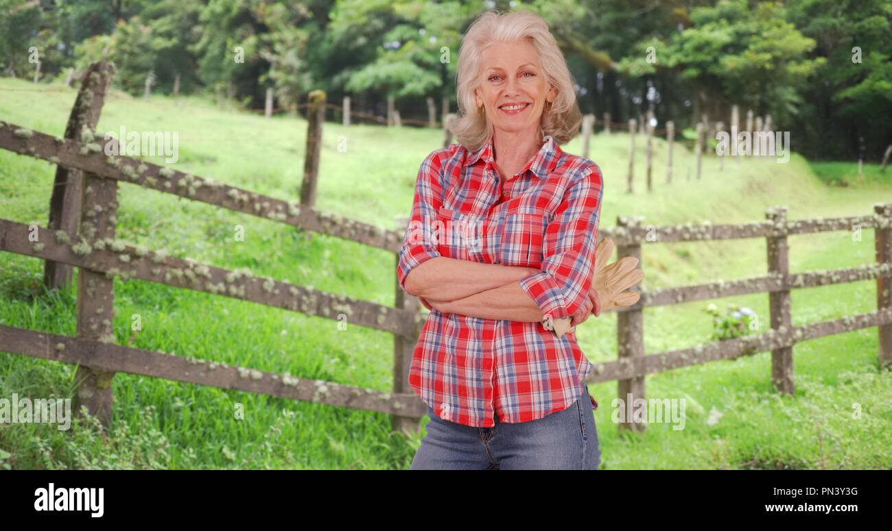 Old Caucasian lady posing with confidence outside at rural country farm ...