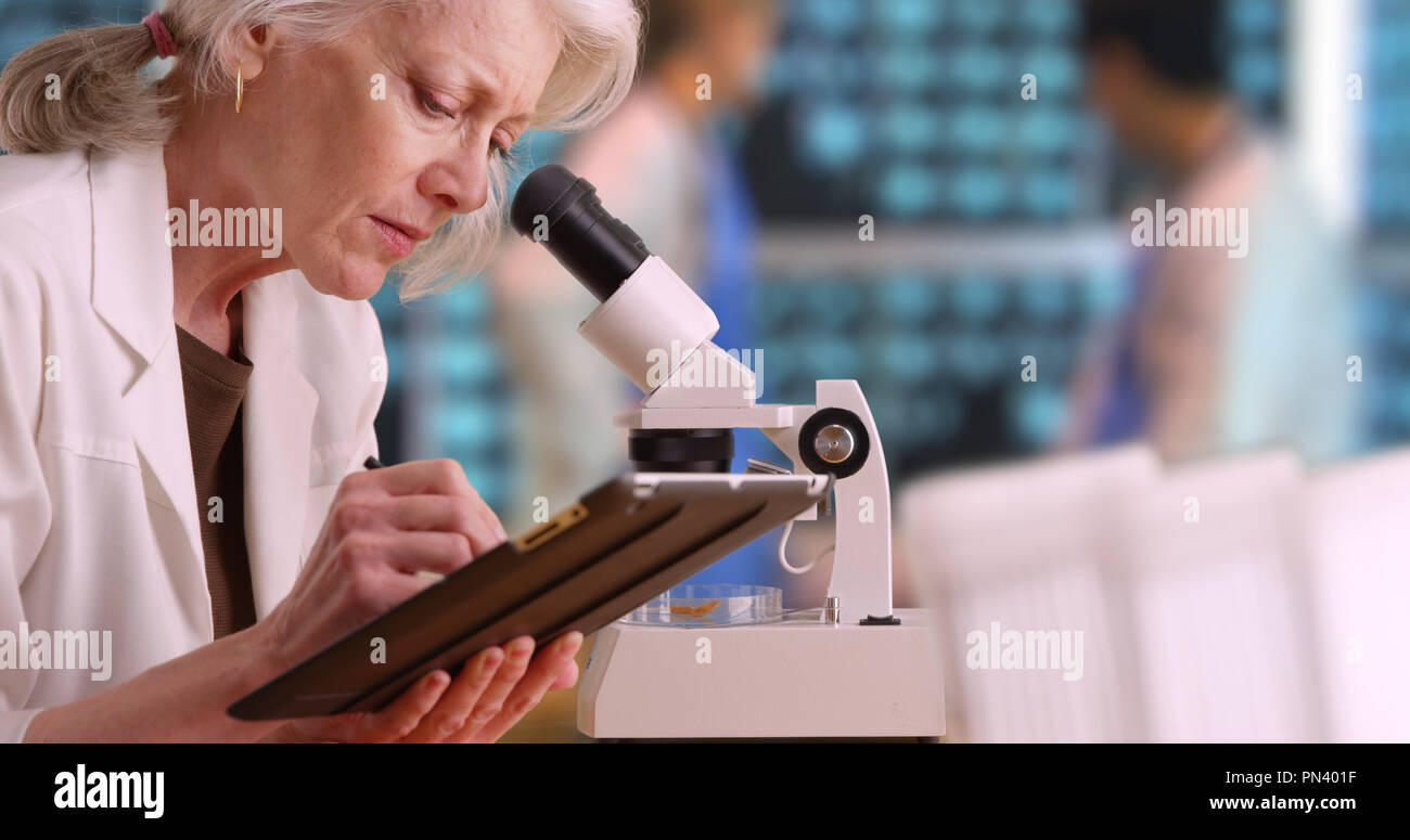 Senior woman doctor taking notes hi-res stock photography and images ...