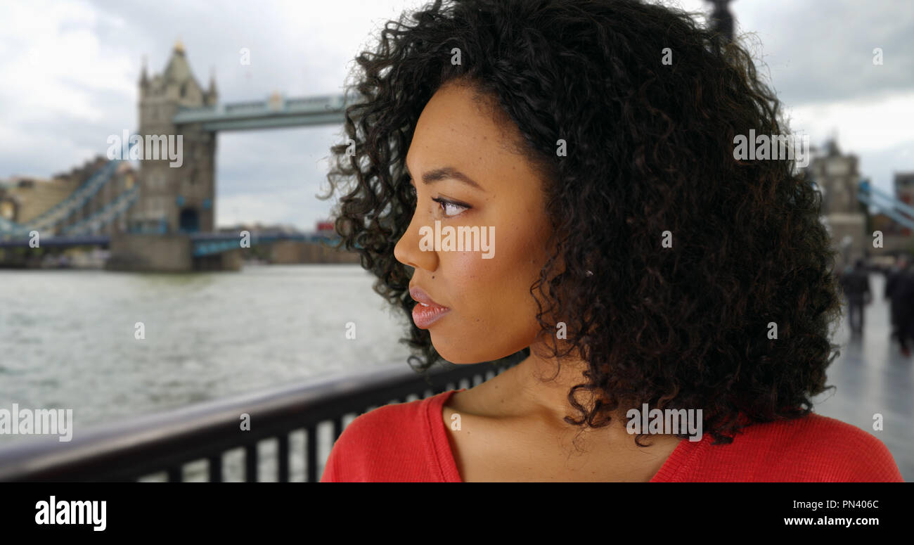 Somber looking black female looking away from camera outside in London ...
