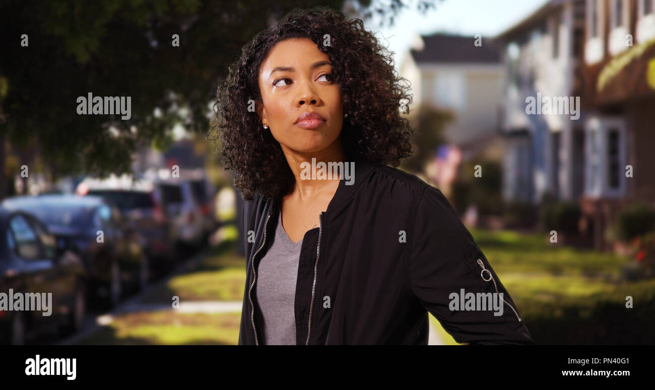 Curly Haired Young African Lady Standing Around Outdoors In Suburban