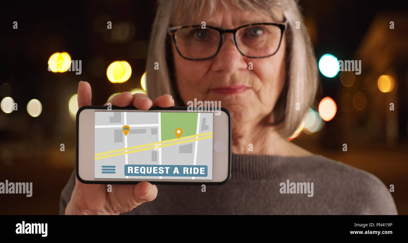 Old woman showing phone screen to camera with rideshare application ...