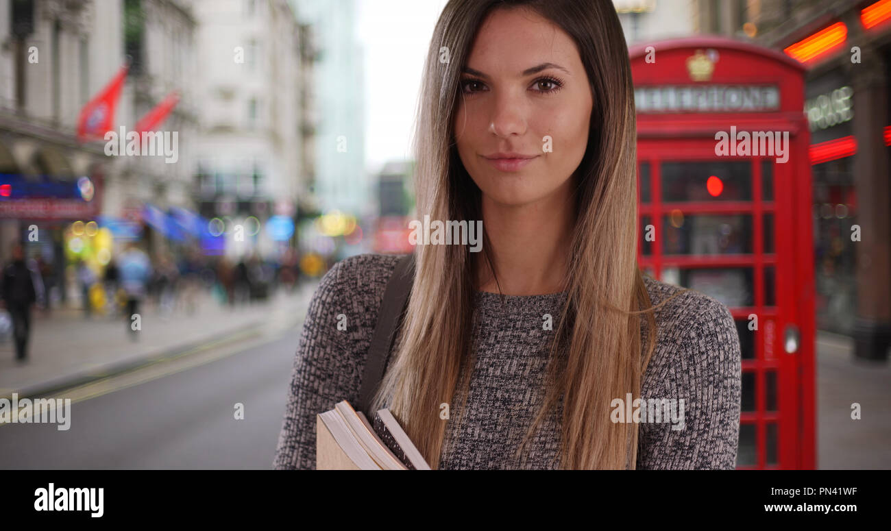 Portrait of young Caucasian female student posing outside in city of ...