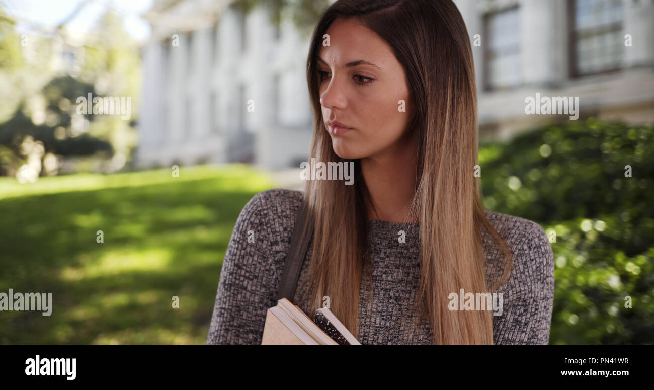 Young Caucasian female college student looking somber on college campus ...