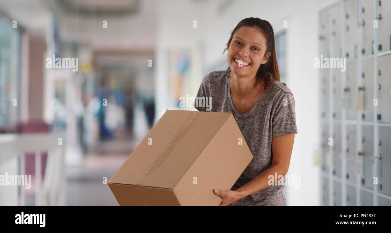 Cheerful young woman at post office holding cardboard package Stock ...