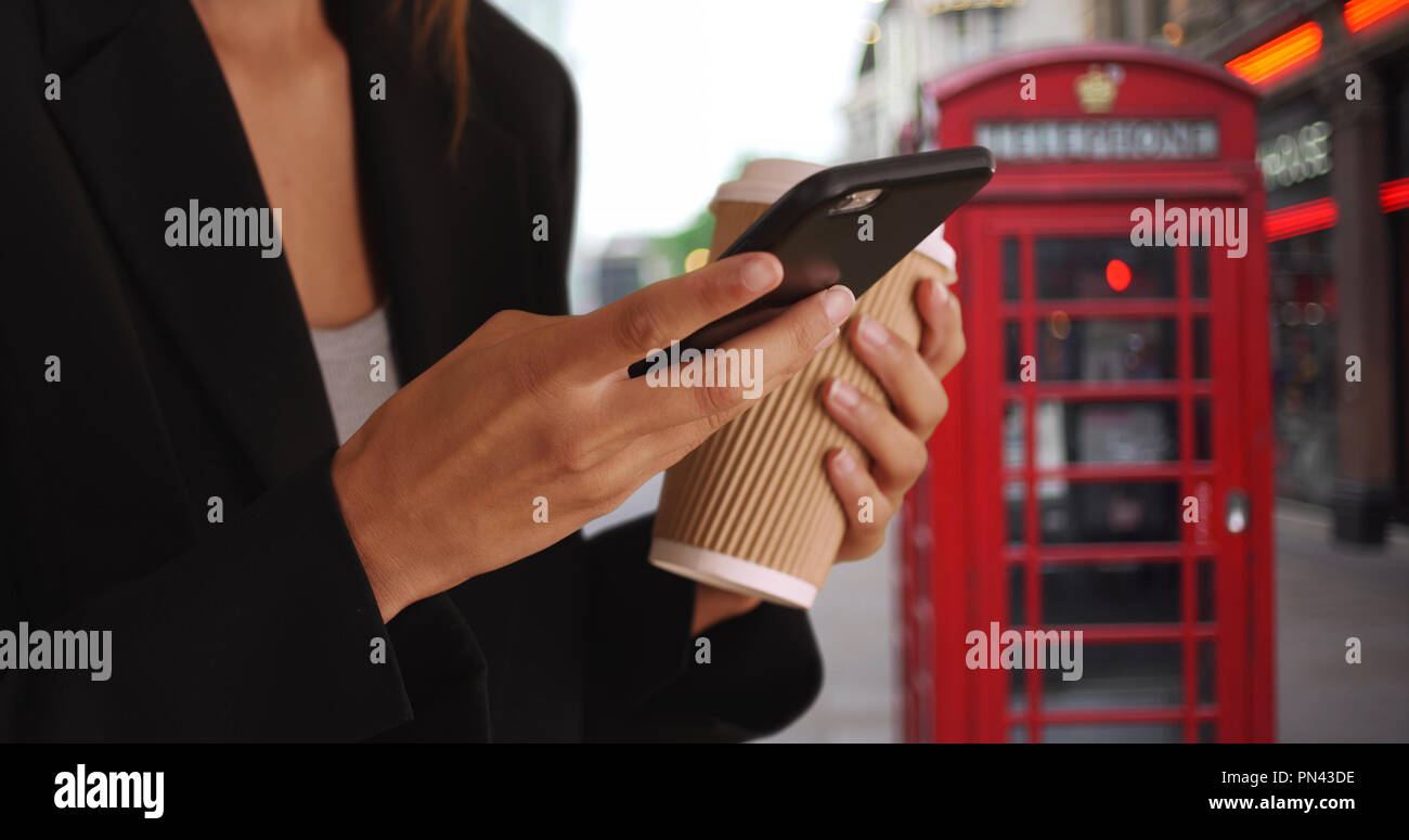 Close up of female hands text messaging on smartphone while downtown in ...
