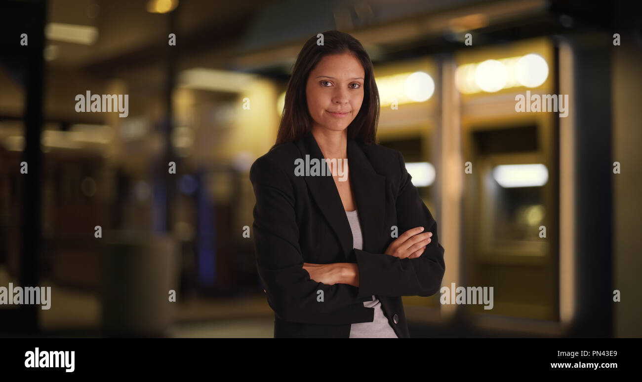 Happy young financial advisor or bank employee outside her local branch ...
