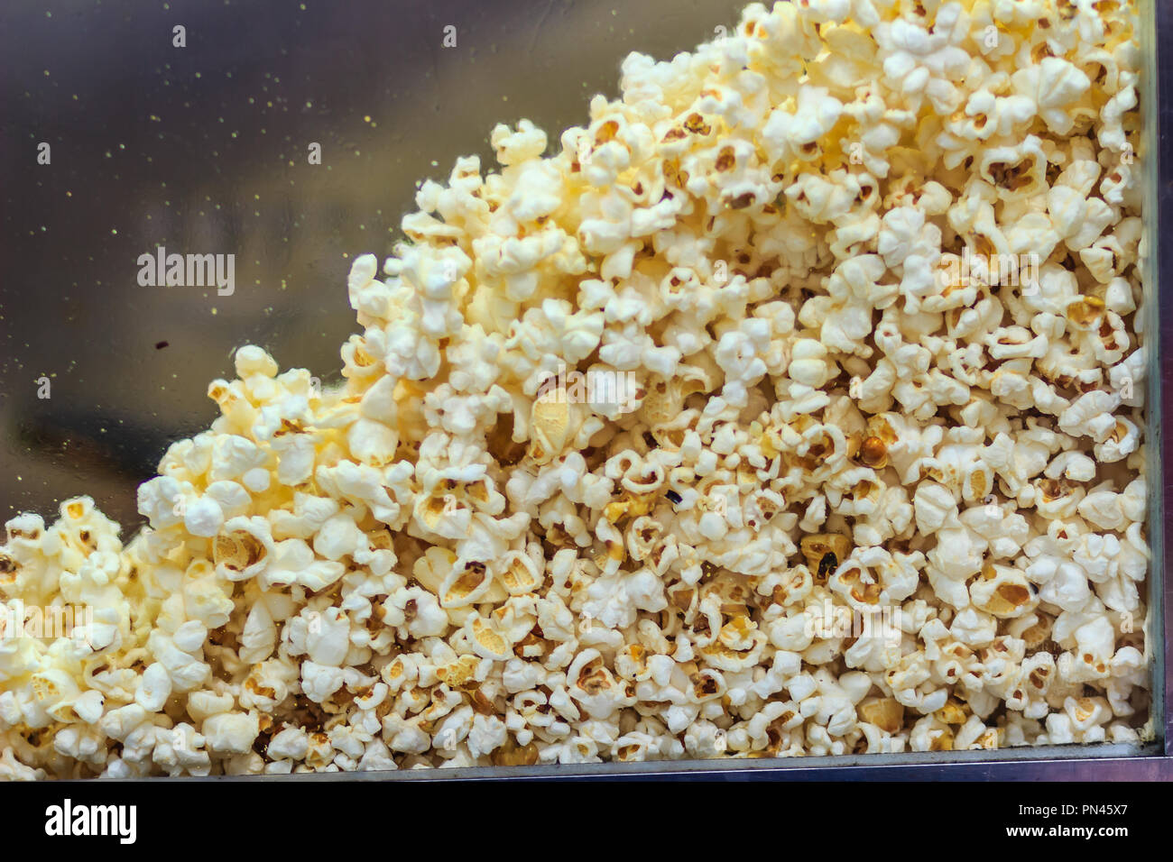 Cooked popcorn in the glass showcase for sale Stock Photo - Alamy