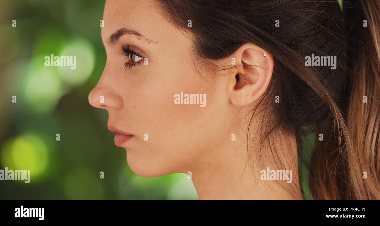 Close-up profile of beautiful model posing on green and white ...