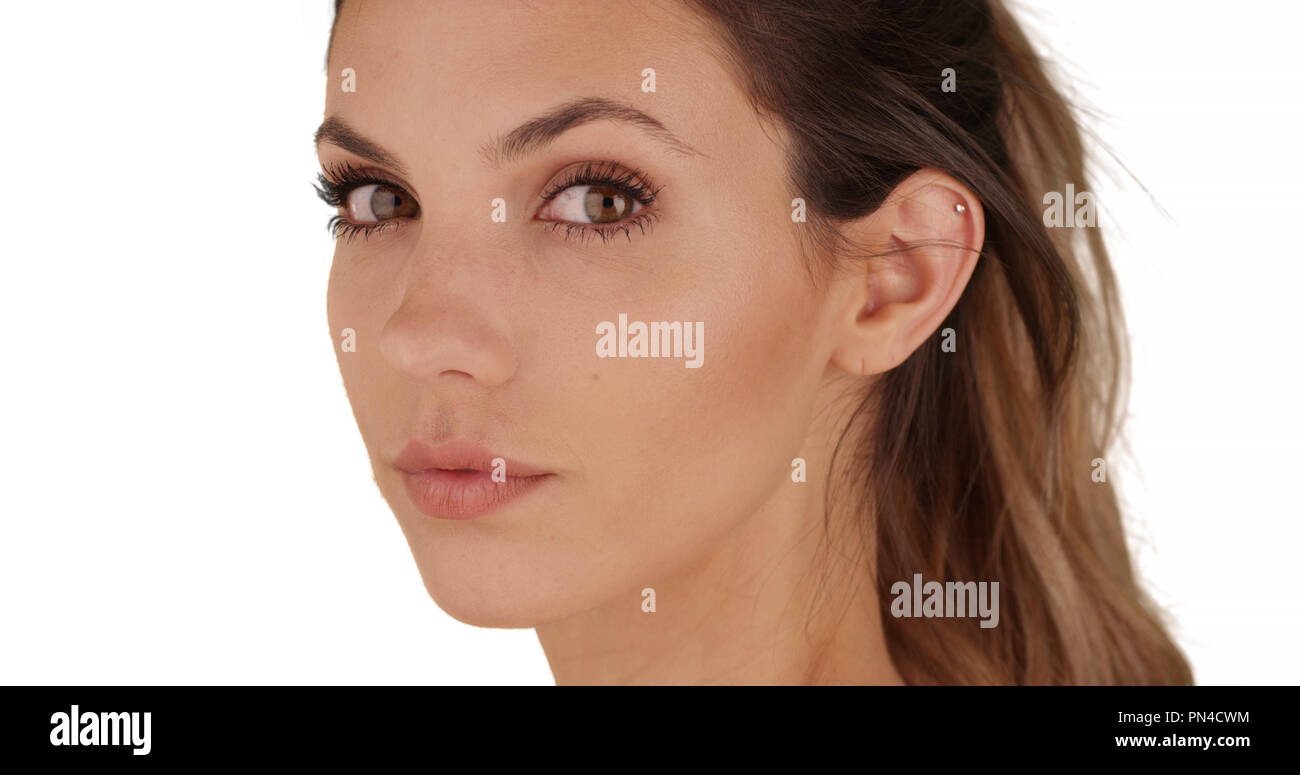 Tight shot of gorgeous young lady turning towards camera on white copy ...