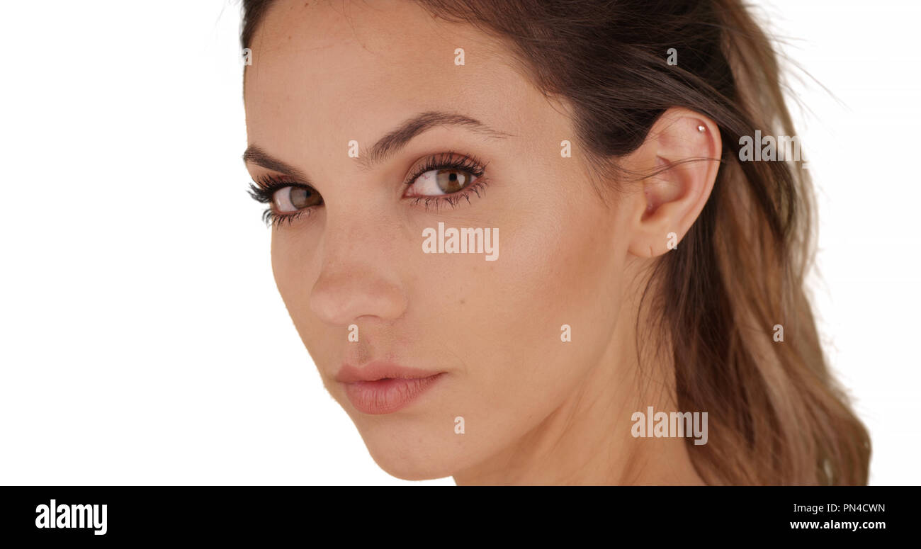 Tight shot of gorgeous young lady turning towards camera on white copy ...