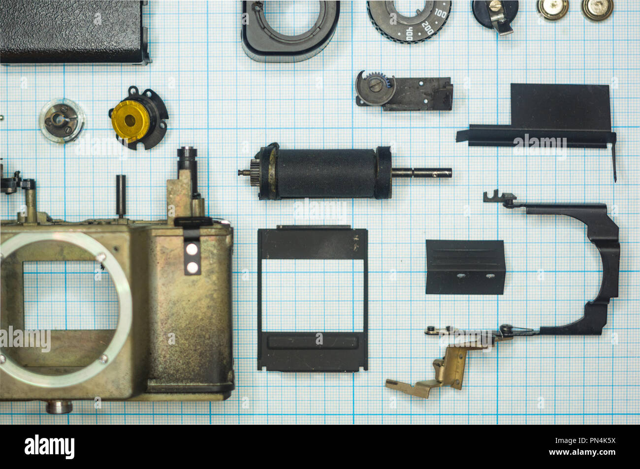 parts are completely disassembled old retro film SLR camera on graph ...