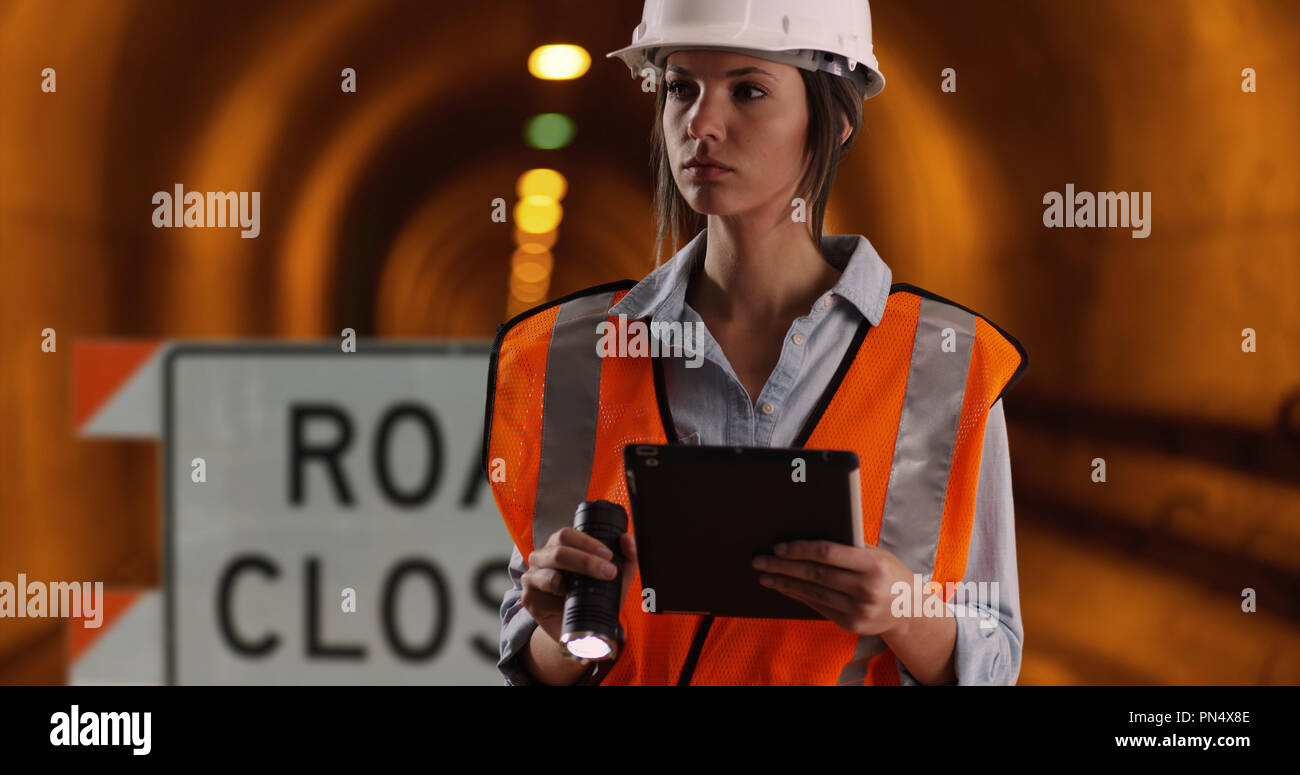 female worker shining flashlight at camera while in tunnel under ...