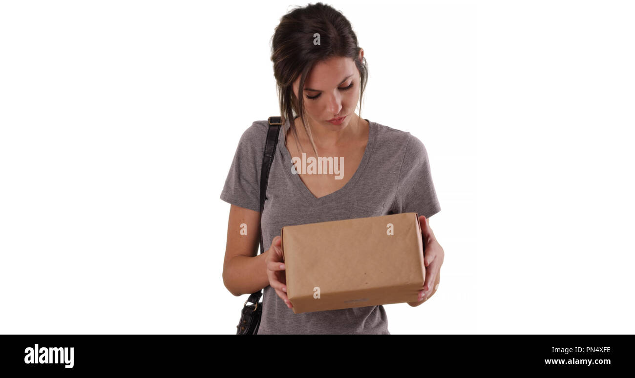 Woman reading address on parcel and walking off screen on white ...