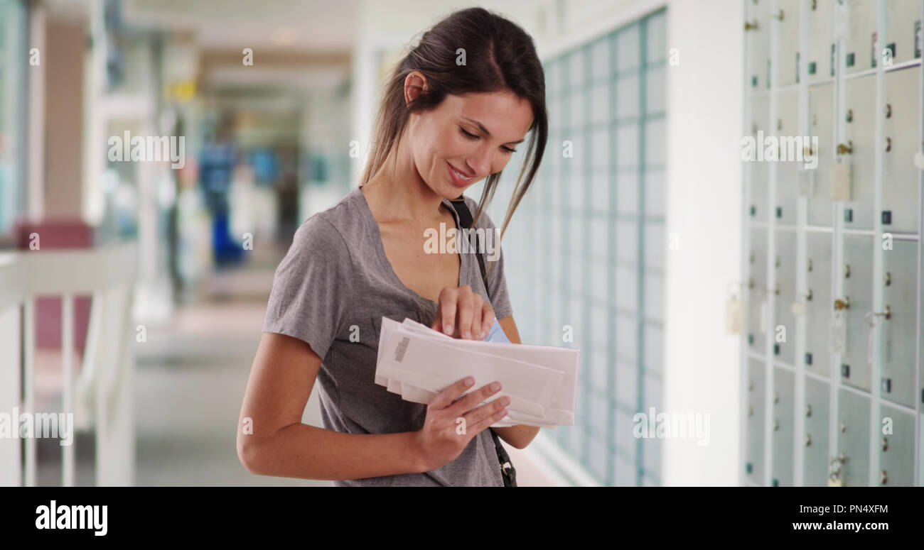 White millennial female checking stack of letters while in post office ...
