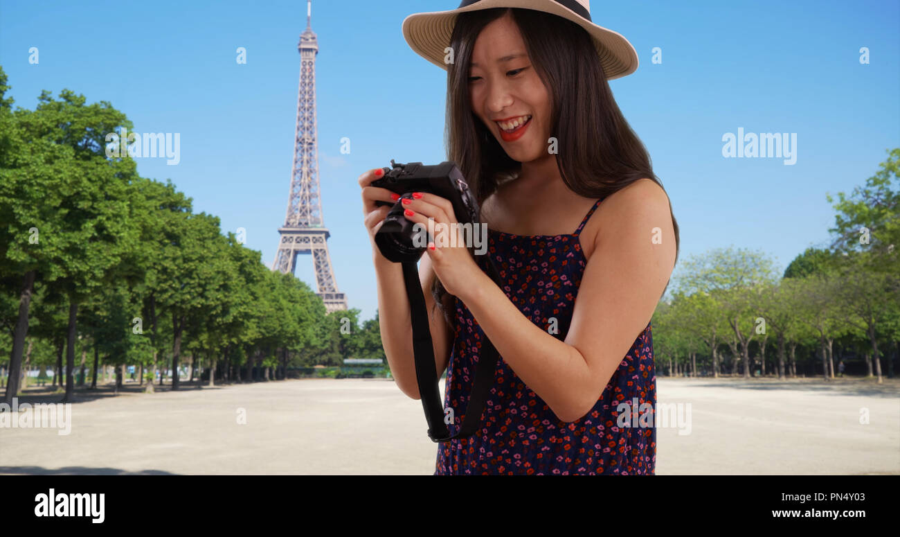 Closeup of Asian millennial photographer taking photos by Eiffel Tower ...