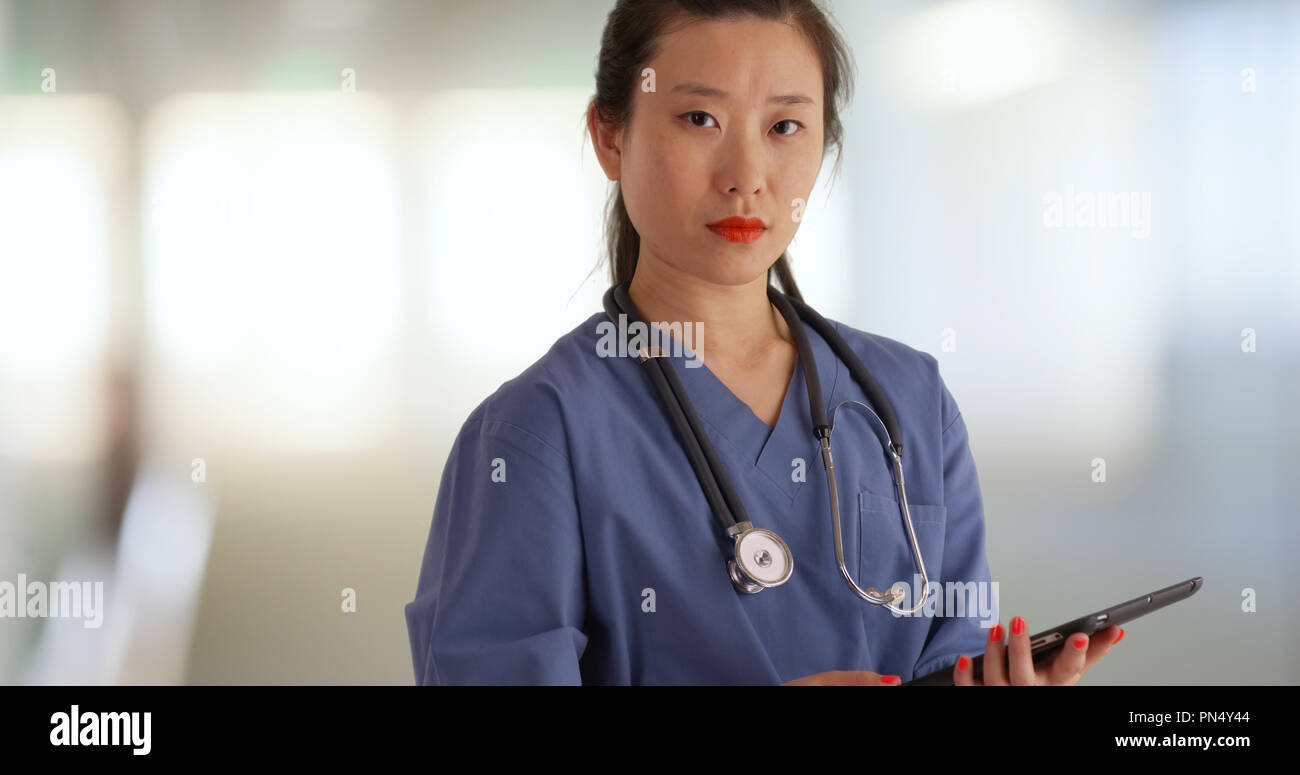Asian millennial nurse or medical doctor using tablet computer in ...