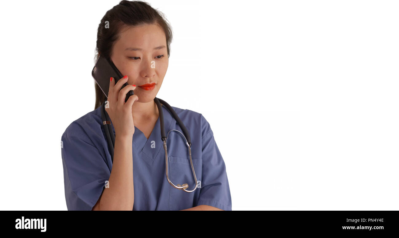 Working millennial nurse in scrubs using smartphone isolated on white ...