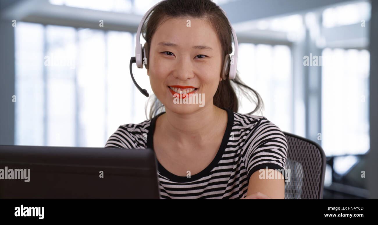Happy female technical support agent with headset smiling at work Stock ...
