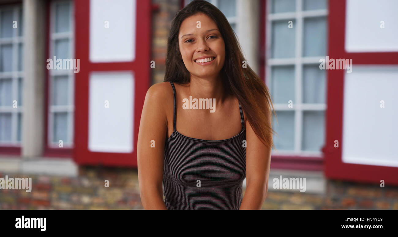 Happy and attractive young woman looking behind her then smiling at ...